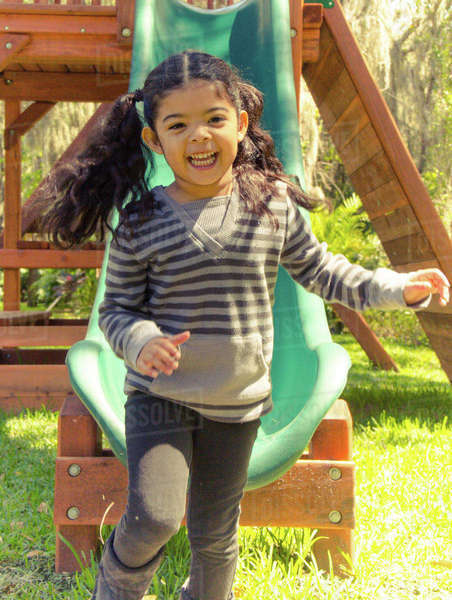 Happy girl getting off slide - Royalty-free Stock Photo | Dissolve