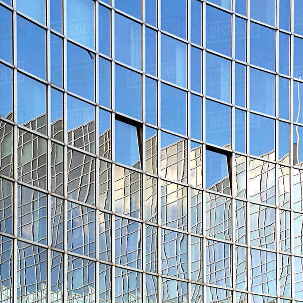 Reflecting in glass facade with two open windows - Stock Photo - Dissolve