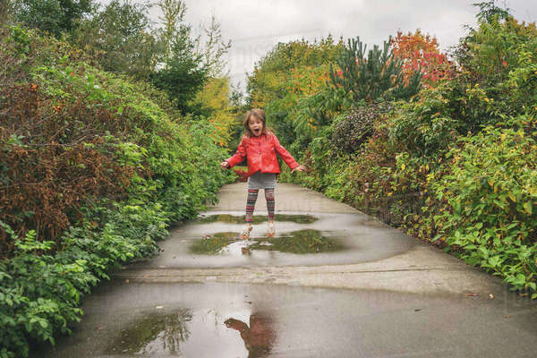 Girl jumping in a puddle - Royalty-free Stock Photo | Dissolve
