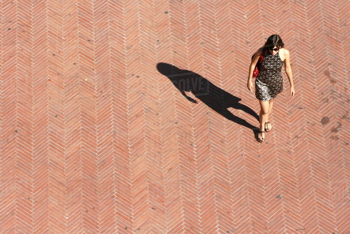 Overhead view of woman walking along street - Royalty-free Stock Photo ...