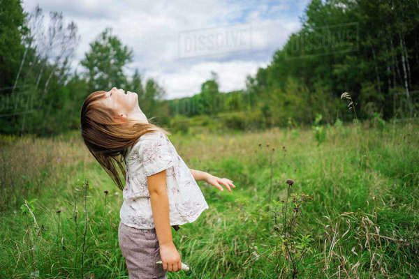 Girl standing in field throwing her head back laughing - Stock Photo ...