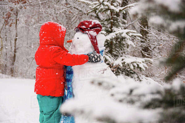 Girl hugging a snowman - Royalty-free Stock Photo | Dissolve