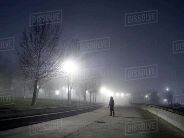 Man standing in street at night - Royalty-free Stock Photo | Dissolve