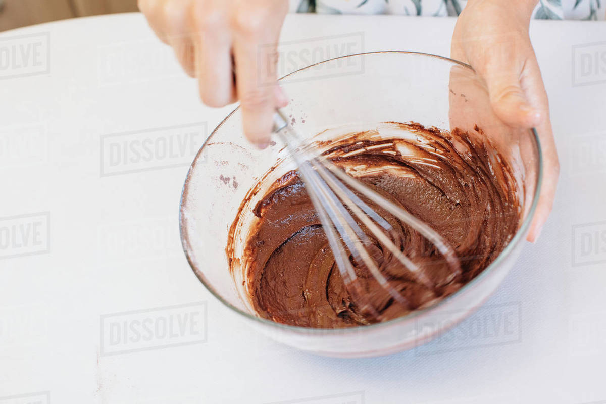 Woman standing in kitchen whisking cake batter - Royalty-free Stock ...