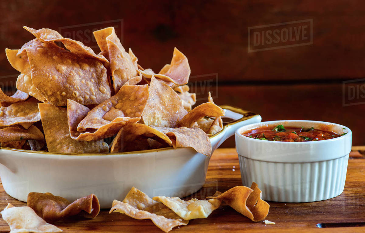 Mexican corn tortilla chips with tomato salsa dip - Stock Photo - Dissolve