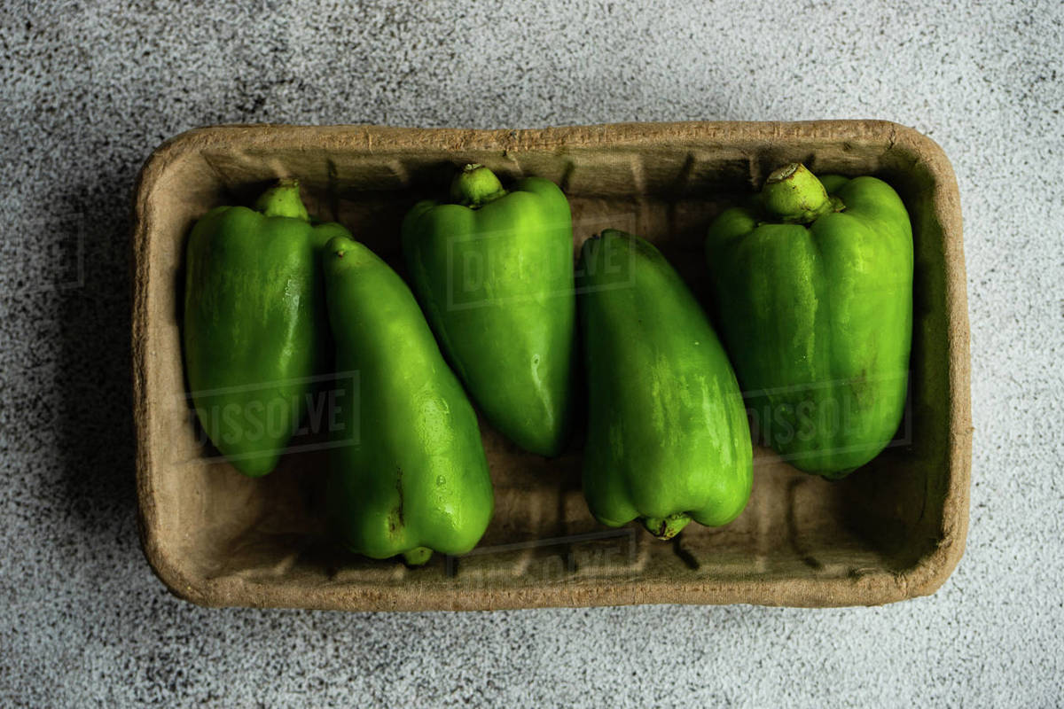 Overhead view of fresh green bell peppers in a cardboard box - Royalty ...