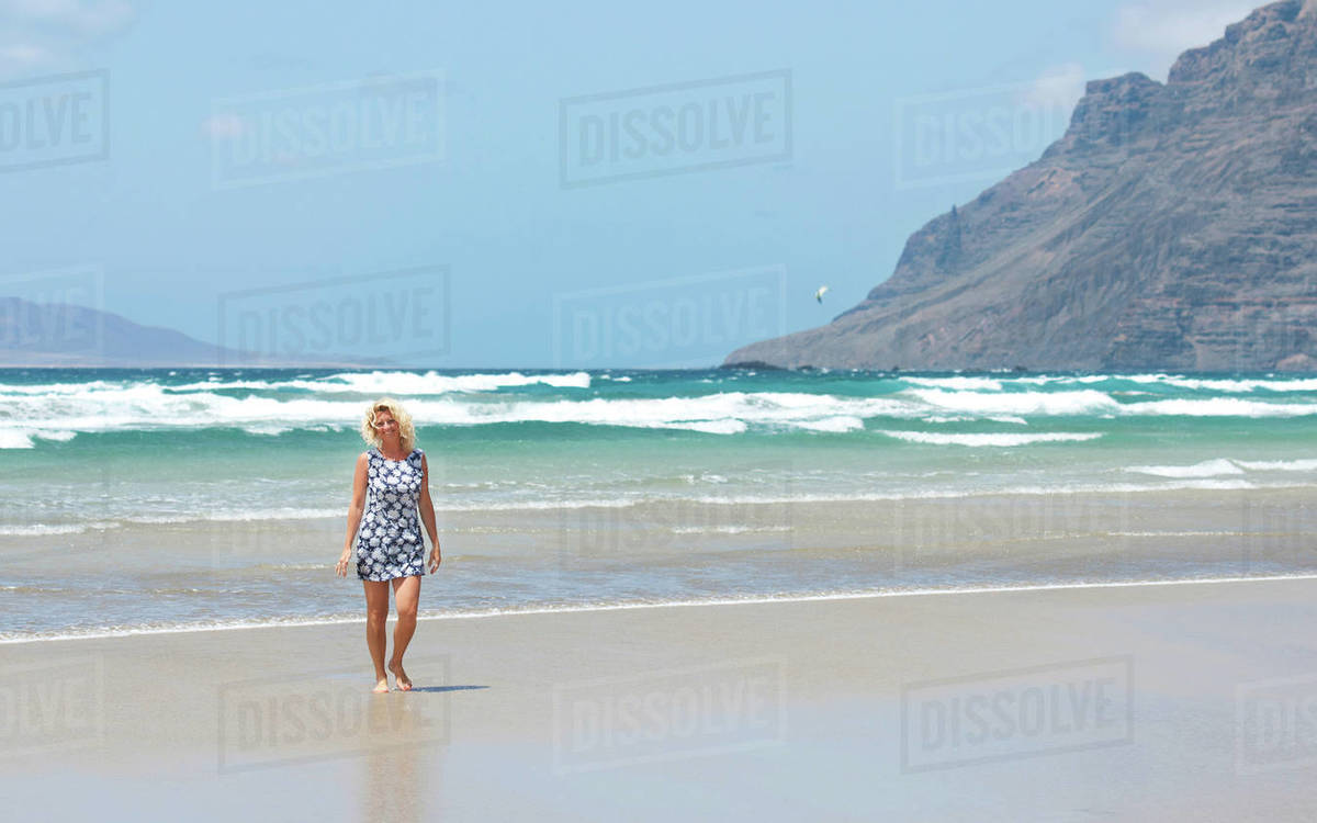 Beautiful woman in a summer dress on Famara beach, Lanzarote, Canary ...