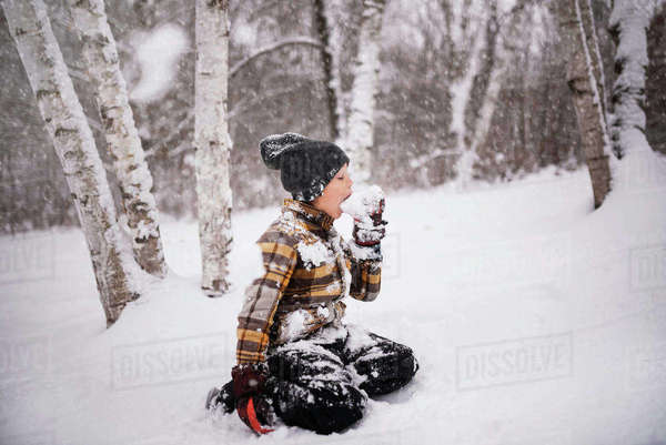 Boy sitting outdoors eating snow, Wisconsin, USA - Royalty-free Stock ...