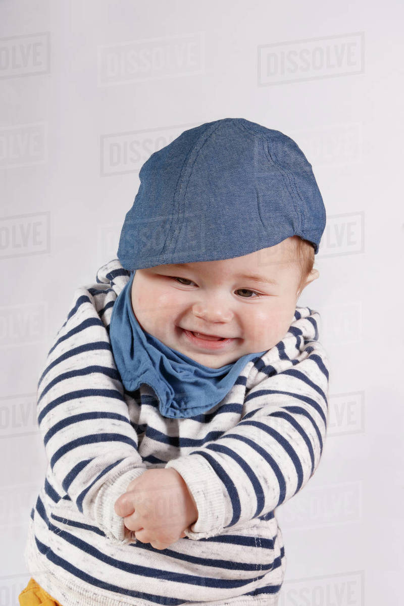 Close-up portrait of a smiling baby boy wearing a bib and hat - Royalty ...