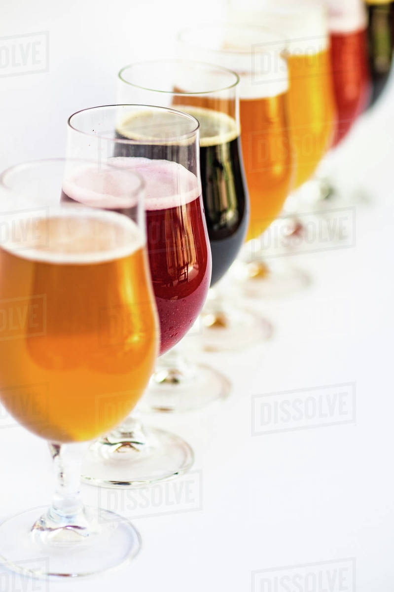 A row of assorted craft beers lined up on a table - Stock Photo - Dissolve