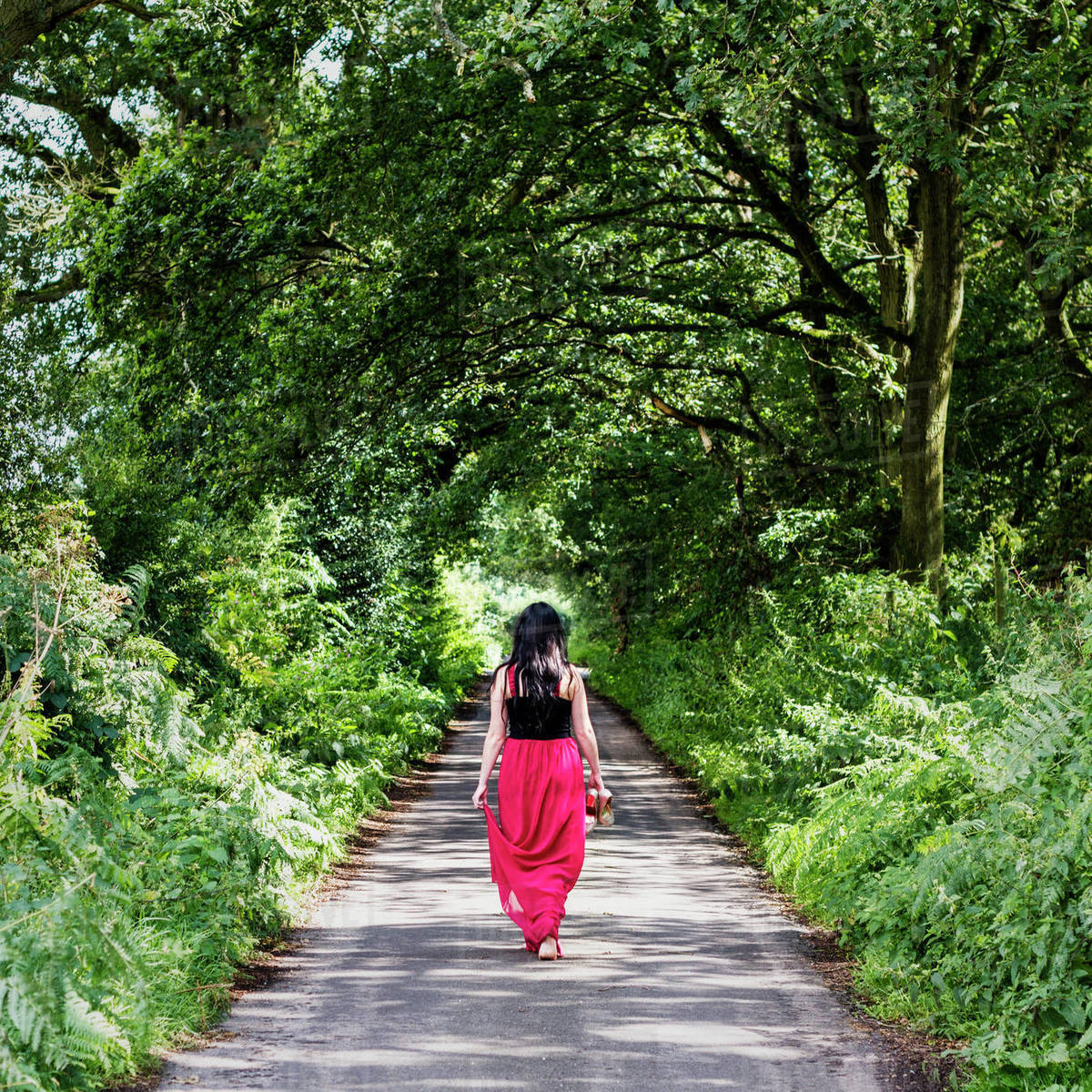 Girl walking on a country lane - Royalty-free Stock Photo | Dissolve
