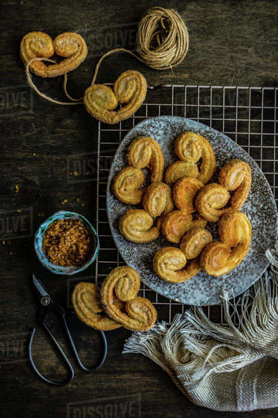 Overhead view of a plate of traditional palmier biscuits on a cooling ...