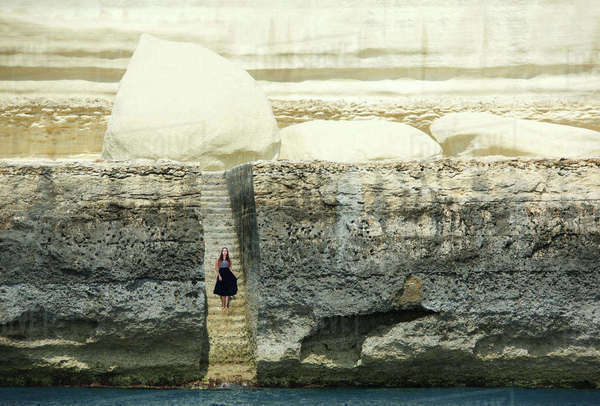 Woman standing barefoot on steps by sea, Il-Blata tal-Melh, Bahrija ...