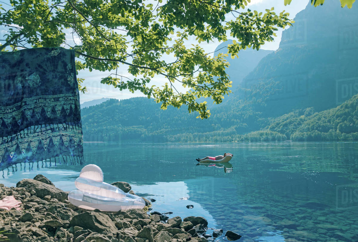Man floating on a lilo, Lake Klontal, Glarus, Switzerland - Stock Photo ...