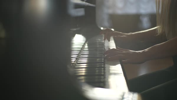 Close-up hands of unrecognizable female pianist playing gentle music on ...