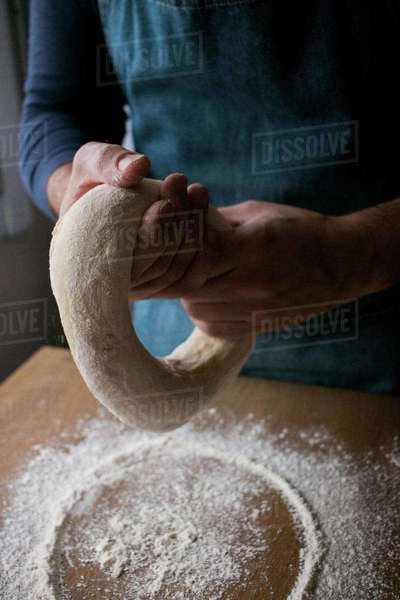 Unrecognizable cook shaping fresh dough with flour while cooking Rosca ...
