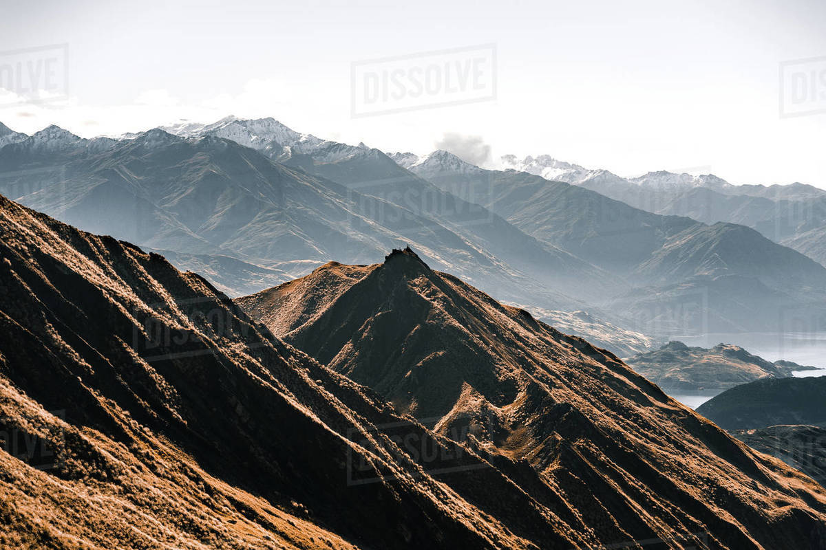Panoramic view of ridge of mountains with high peaks in sunny haze ...