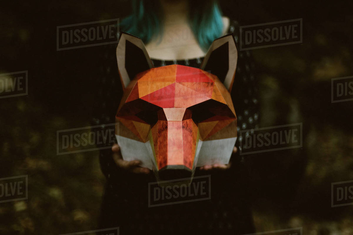 Anonymous female holding paper fox mask in mysterious autumn forest in ...