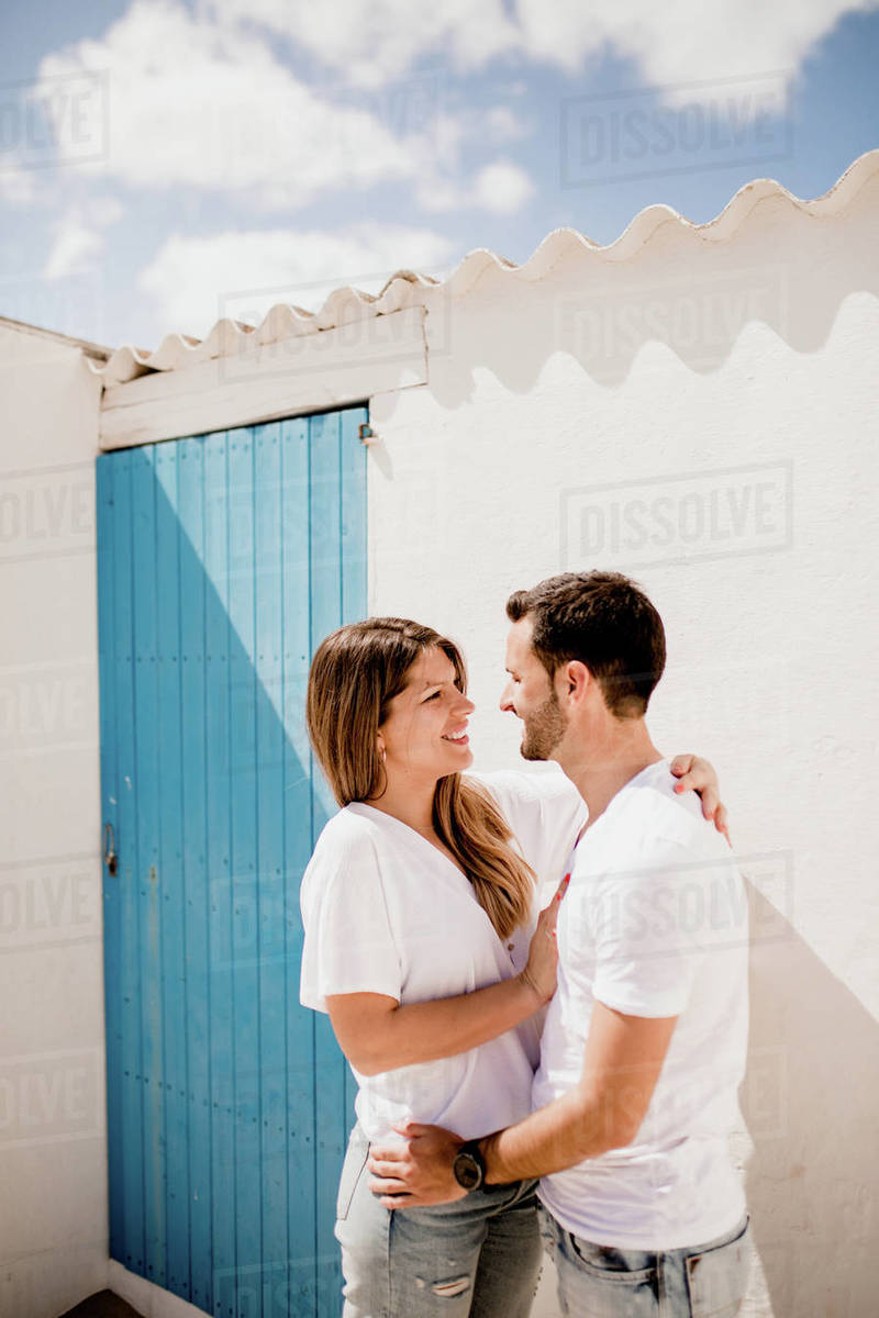 Loving couple cuddling near beach house - Stock Photo - Dissolve