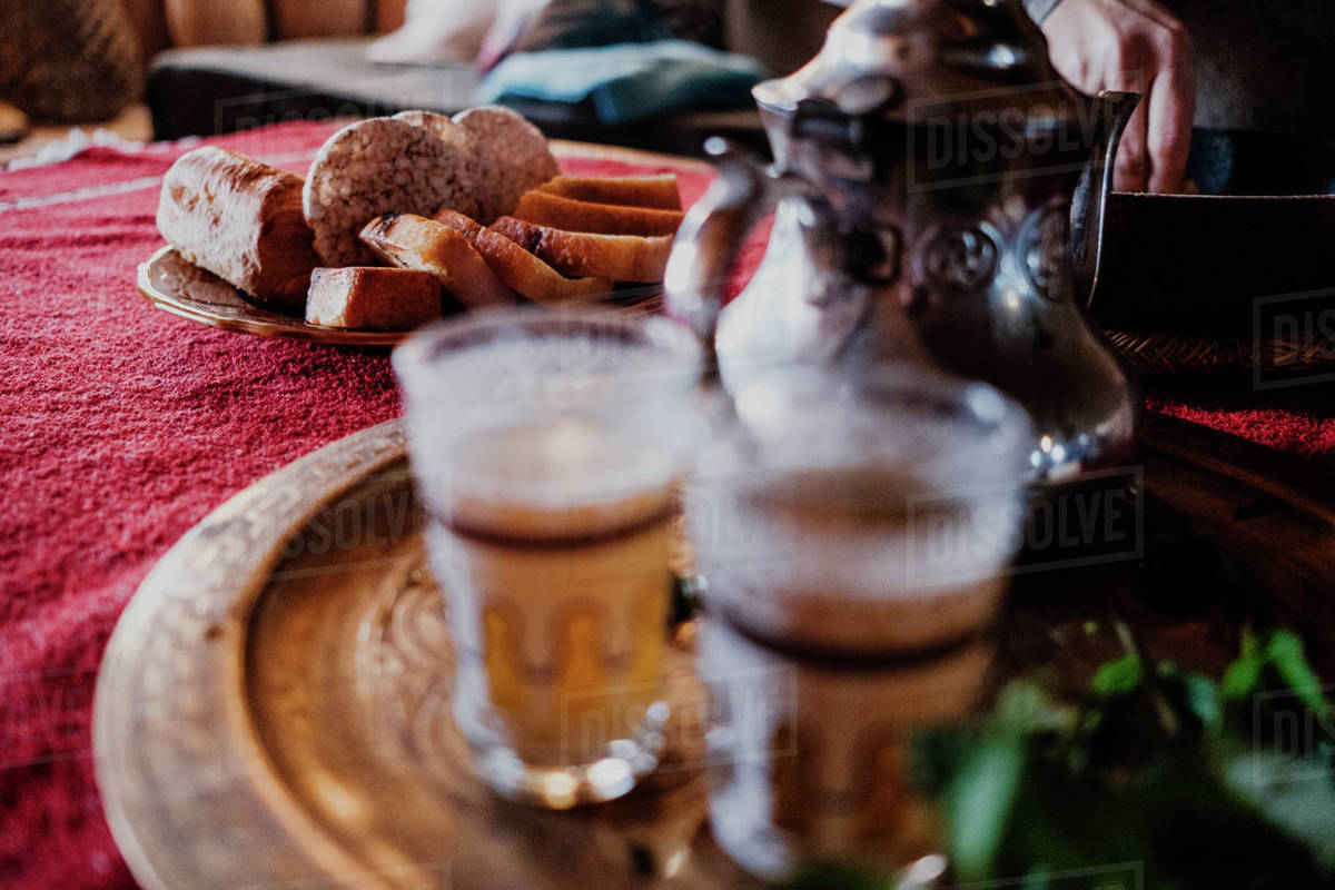 Set of traditional Arab dessert and tray with teapot and cups placed on ...