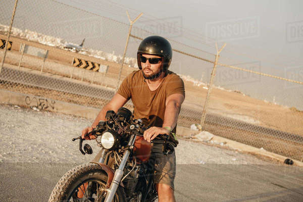 Strong man driving motorcycle - Stock Photo - Dissolve