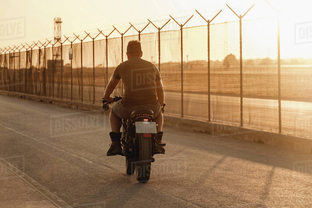 Strong man driving motorcycle - Stock Photo - Dissolve