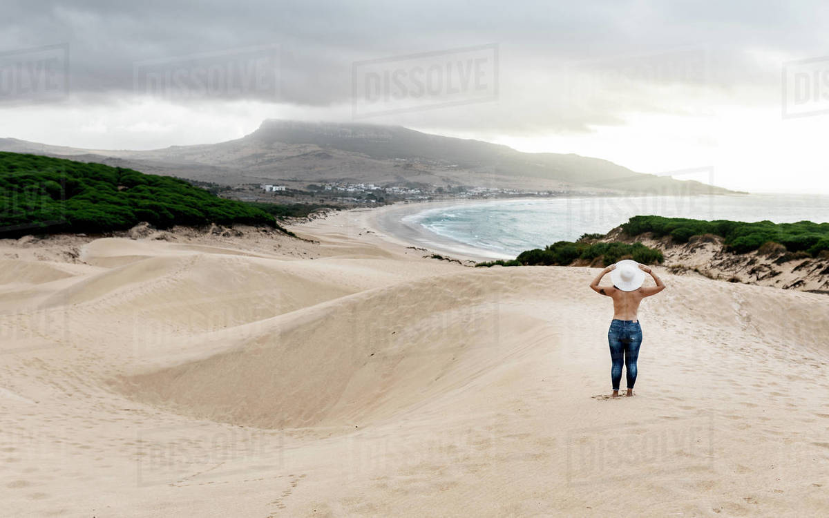 Back view full length shirtless woman wearing denim jeans and hats ...