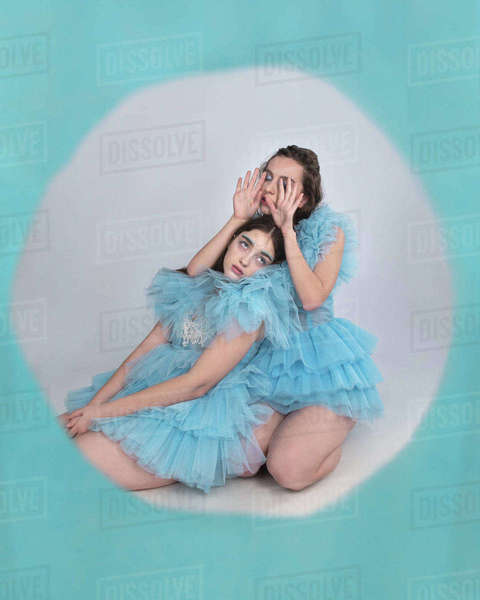 Gentle female models with bored face expression wearing similar blue ...