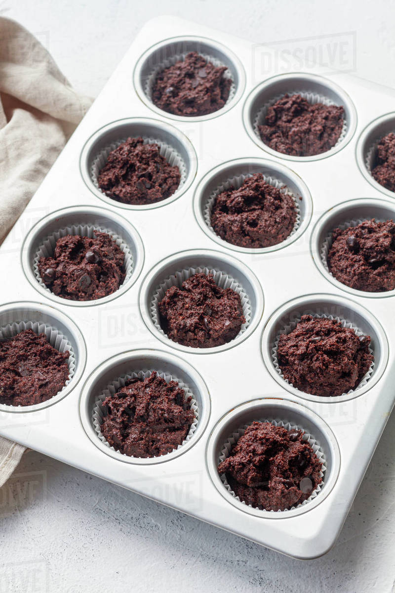 From above chocolate muffin dough into muffin case on baking pan in ...