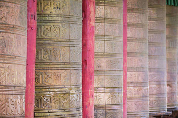 Old stone Tibetan rolls with sacred mantra consisting of sanskrit ...