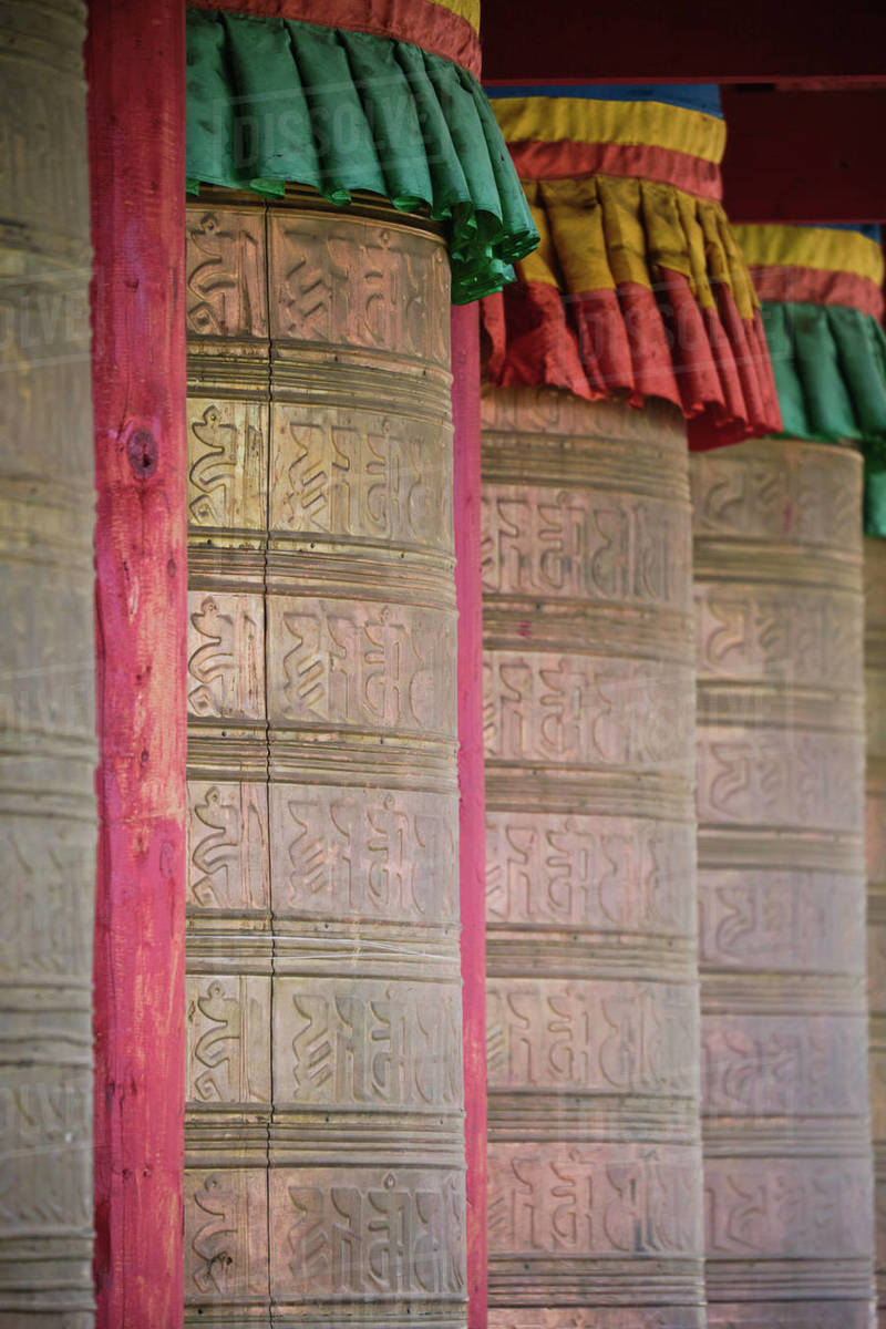 Old stone Tibetan rolls with sacred mantra consisting of sanskrit ...