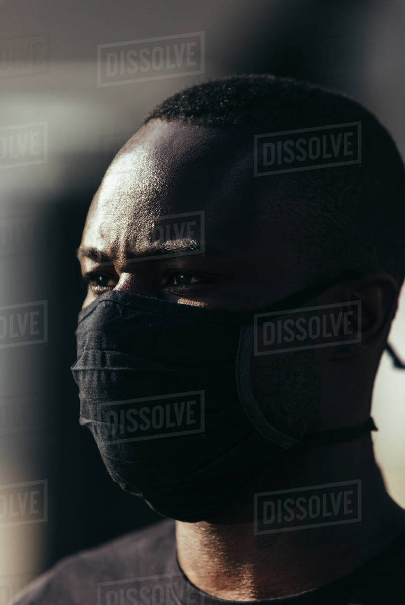 Closeup portrait of african american man wearing a black mask. He is ...