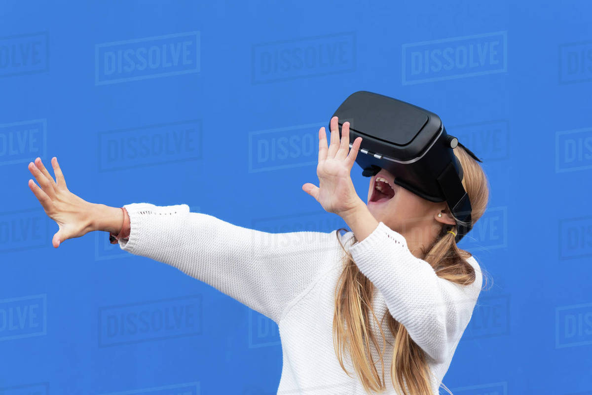 Positive girl playing VR at studio - Royalty-free Stock Photo | Dissolve