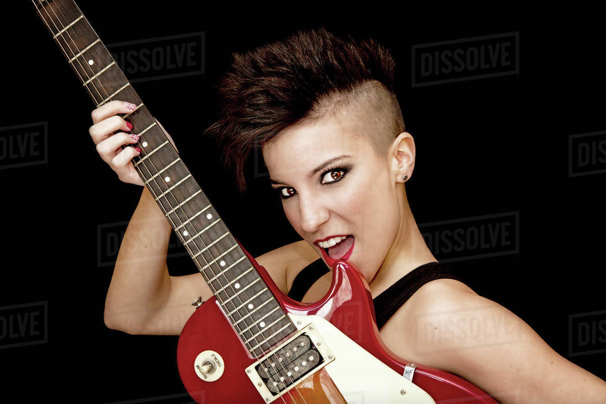 Focused young female rocker with electric guitar in studio - Stock ...