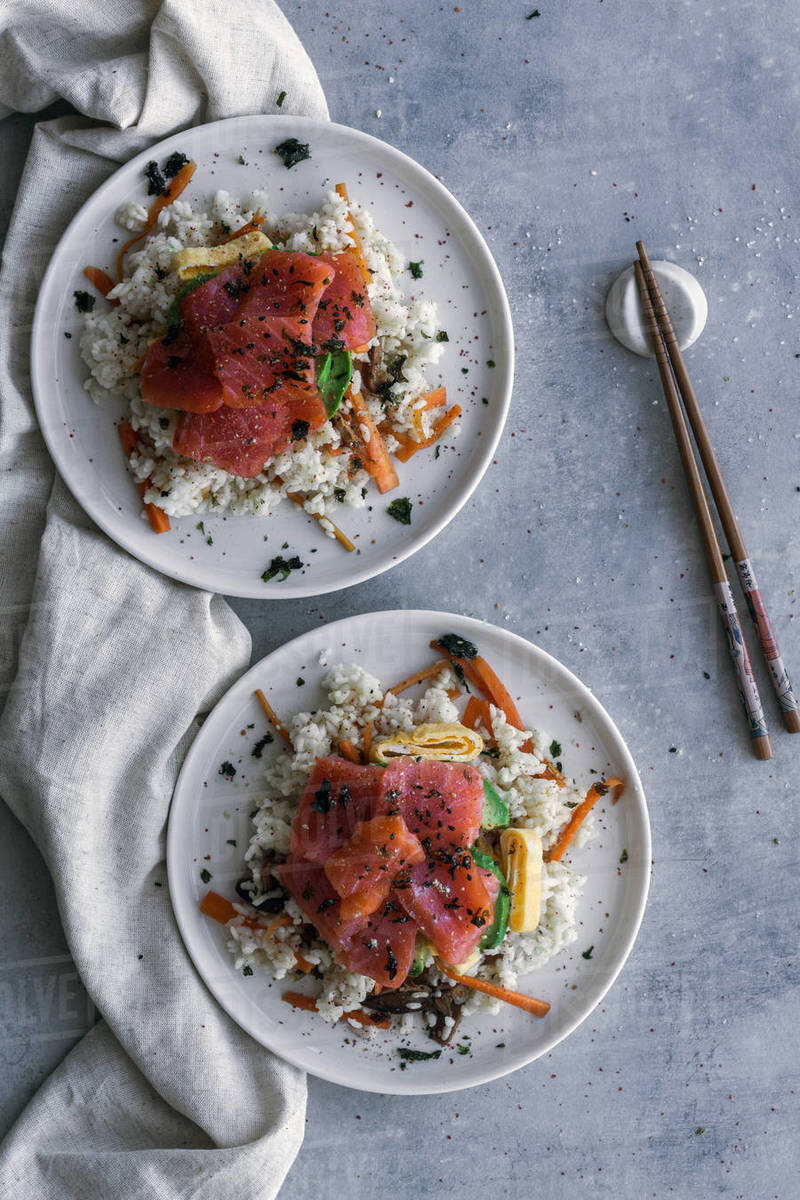 From above tasty appetizing sliced salmon on white rice with vegetables ...