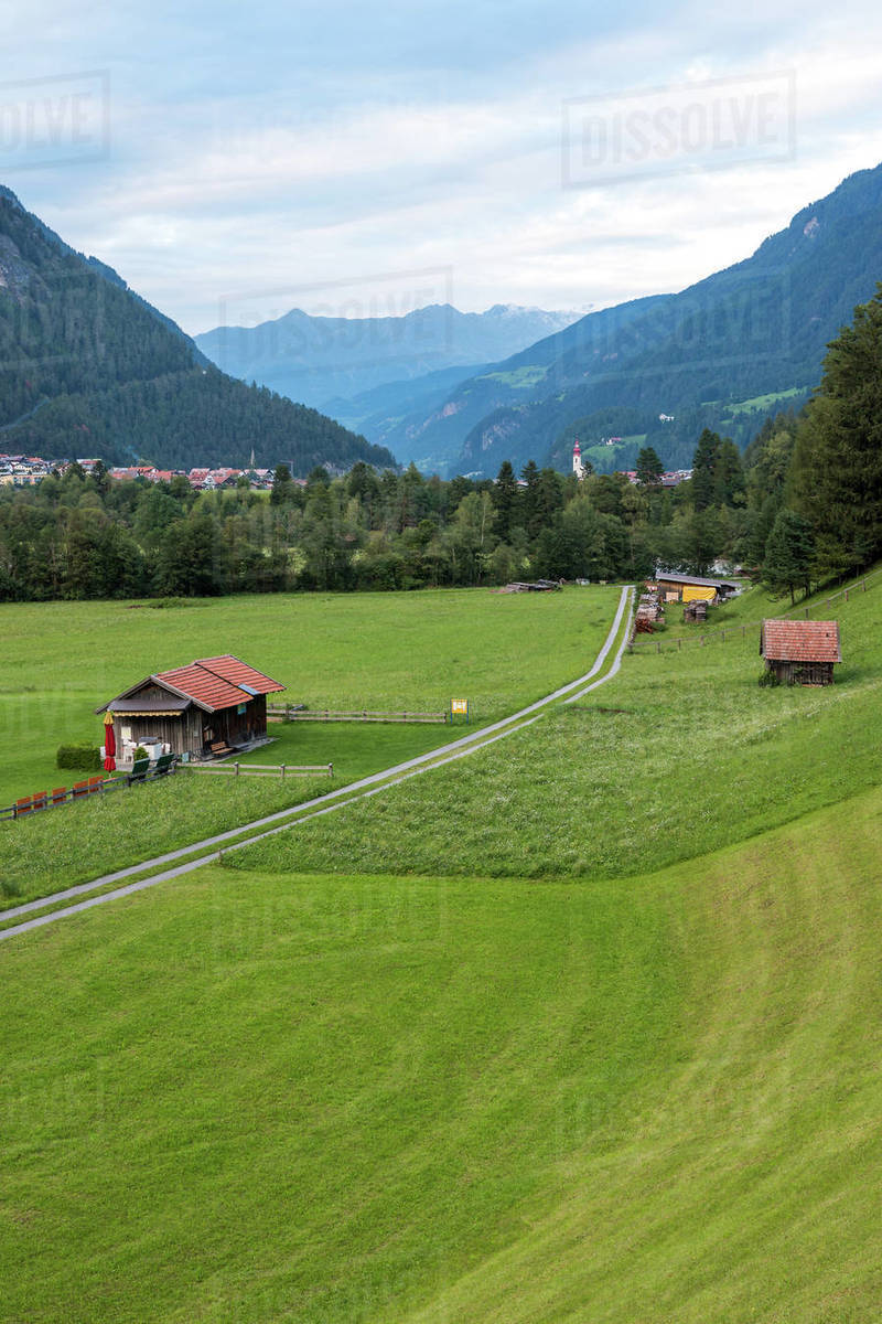 Lovely farm shacks located near road in green valley against mountain ...
