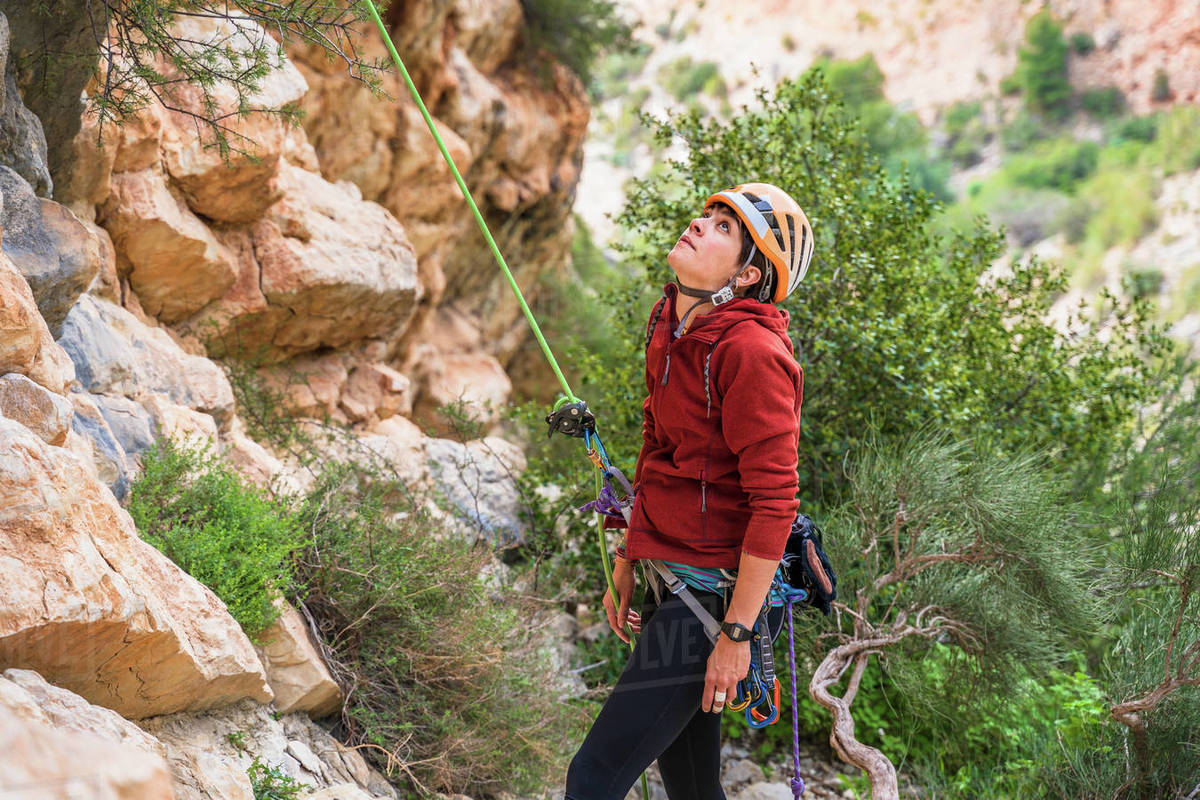 From above concentrated female climber looking up and getting ready for ...