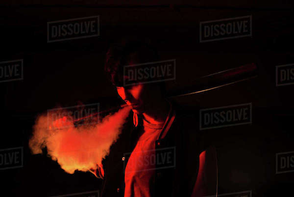 Contemporary female in bomber jacket holding a black baseball bat on ...