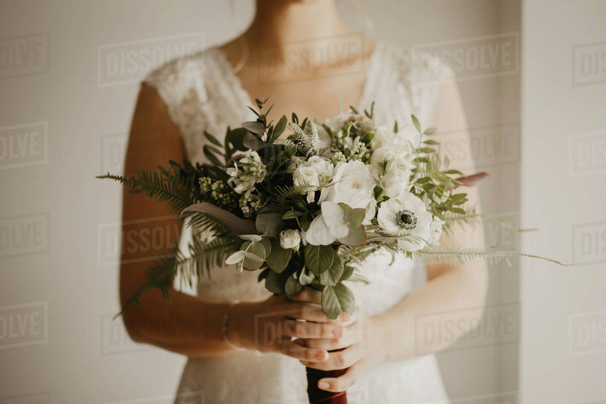 Faceless woman in white lace dress showing beautiful bridal bouquet ...