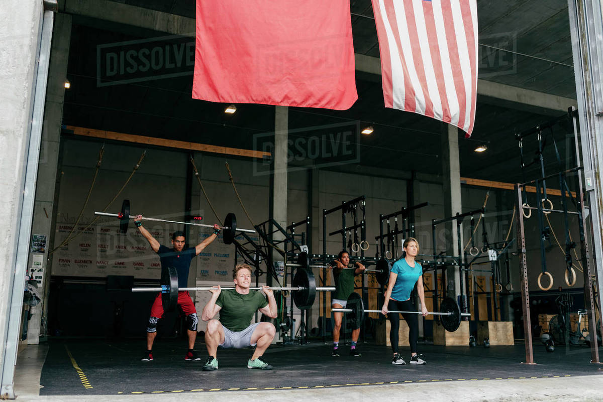 Group of people lifting weights - Stock Photo - Dissolve