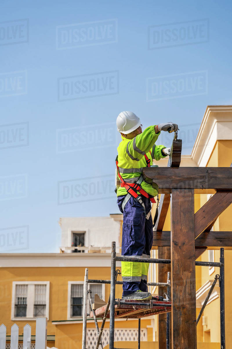 From below side view of male technician in work wear standing on ...
