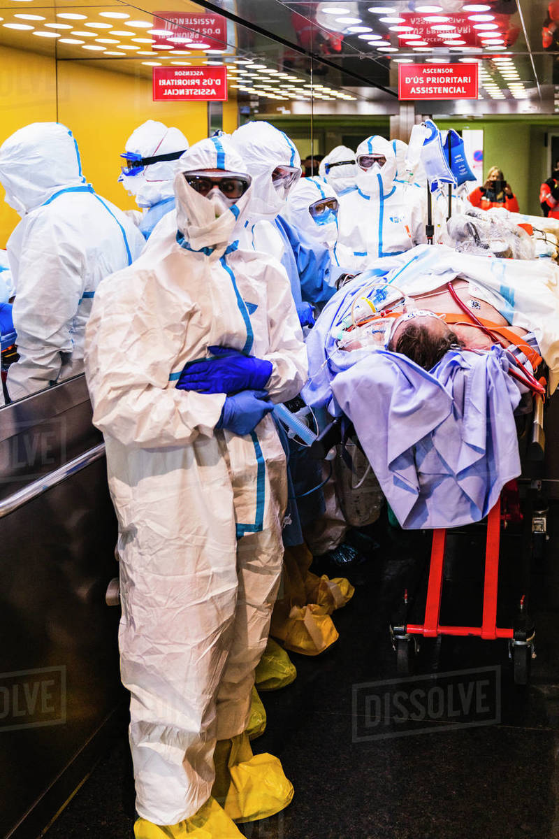 Group of anonymous doctors in protective uniform and mask standing ...