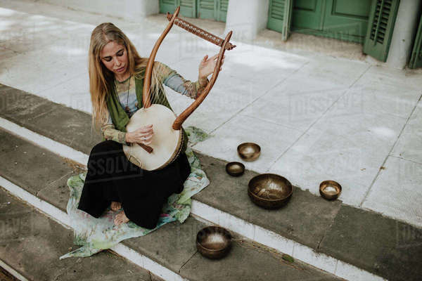 Female playing lyre on steps - Royalty-free Stock Photo | Dissolve