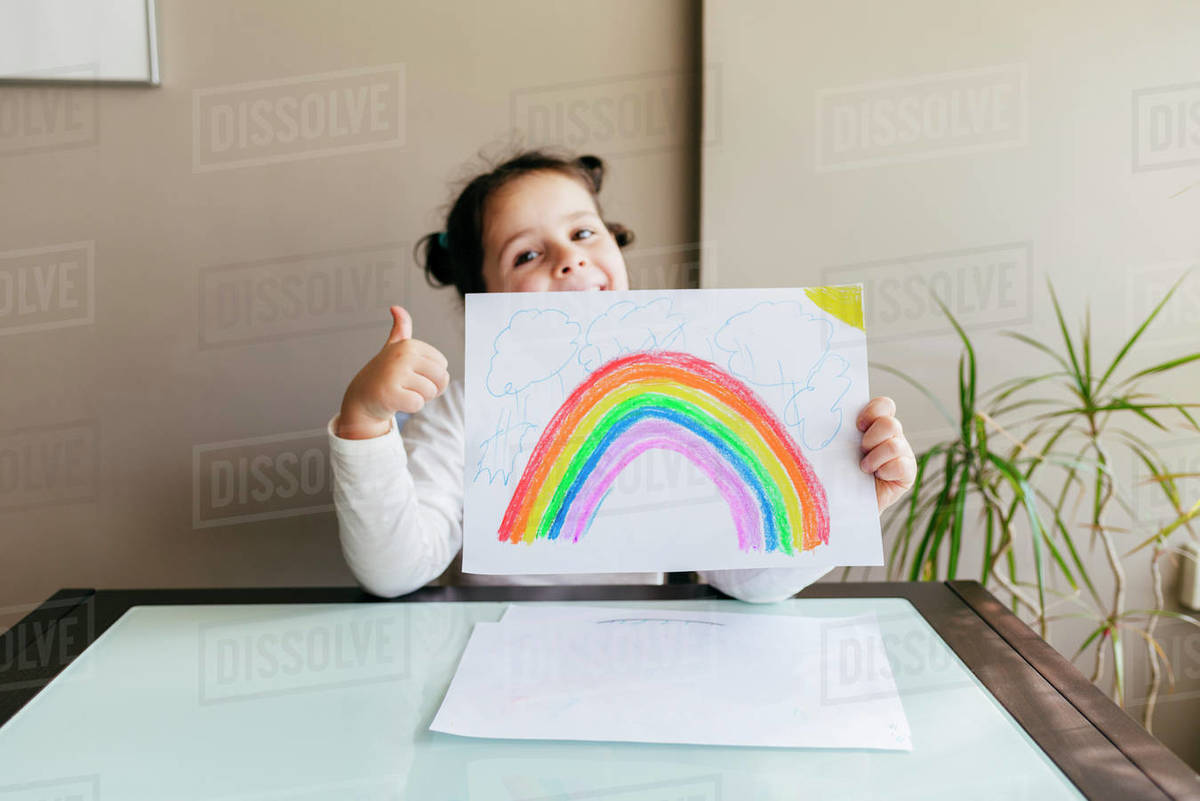 Smiling charming girl holding sheet of paper with colorful drawing ...