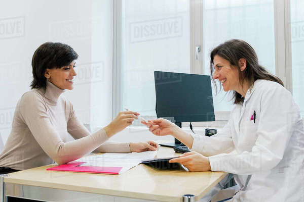 Side view of content female therapist in uniform interacting with ...