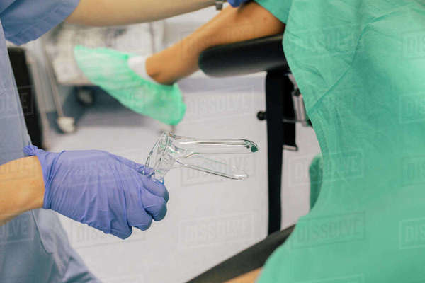 Faceless female doctor in blue gloves and uniform with plastic ...