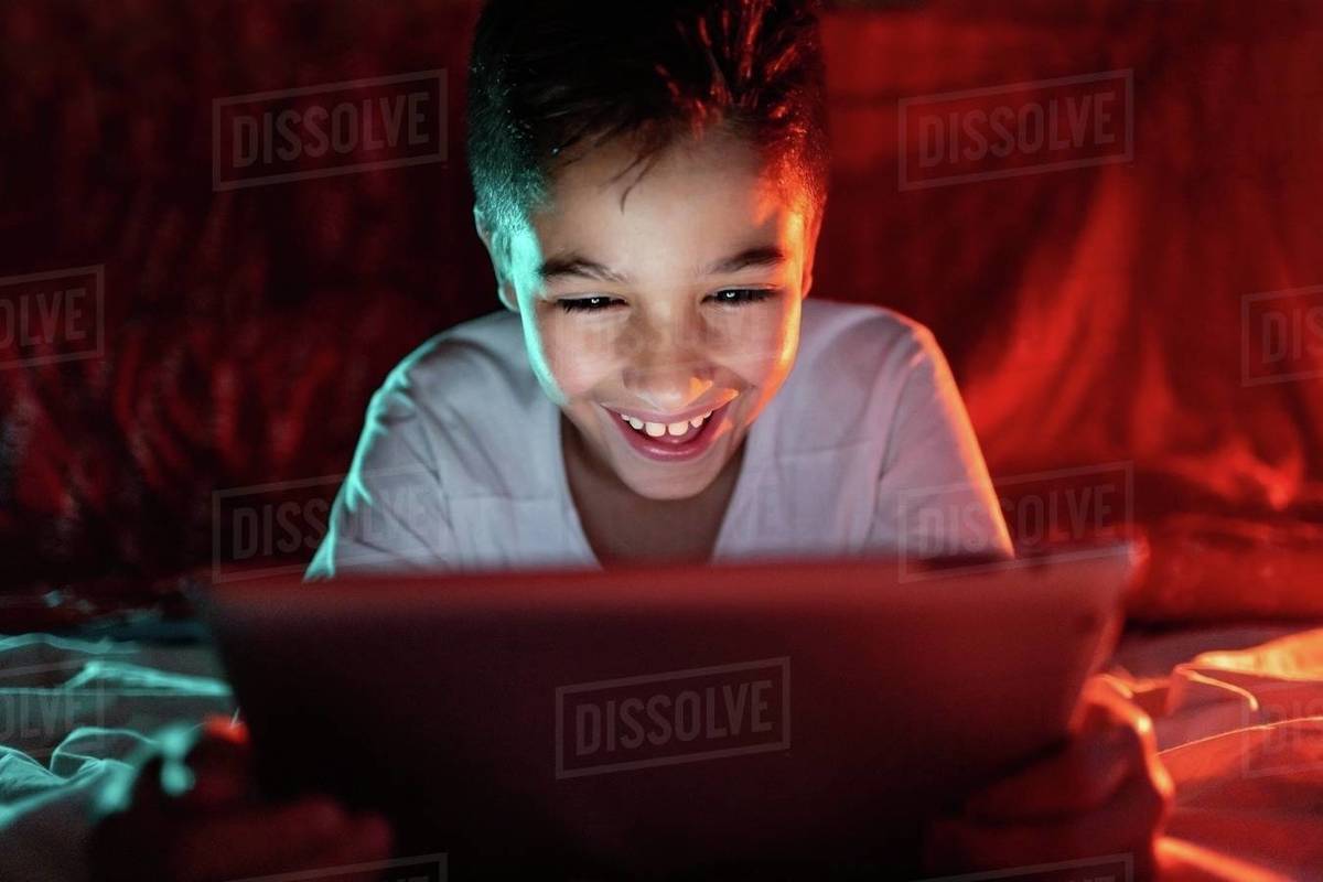 Delighted boy watching cartoon on tablet - Stock Photo - Dissolve