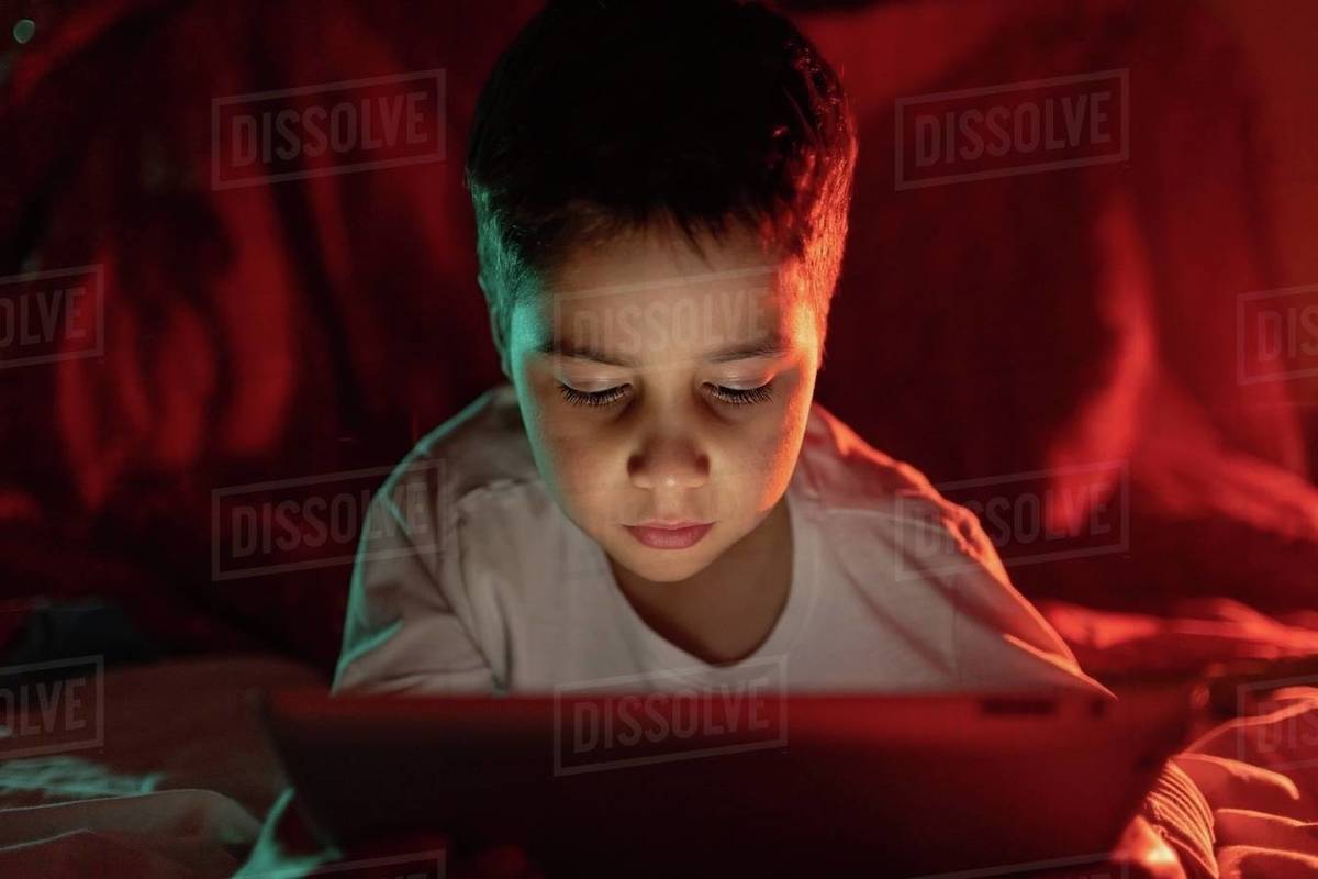 Delighted boy watching cartoon on tablet - Stock Photo - Dissolve
