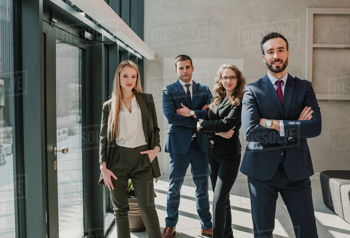 Group of office colleagues in elegant dark suits standing together ...