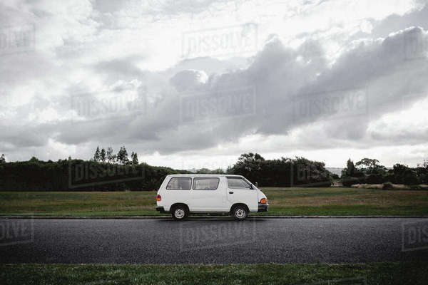 White van riding on asphalt countryside road on majestic cloudy day in ...